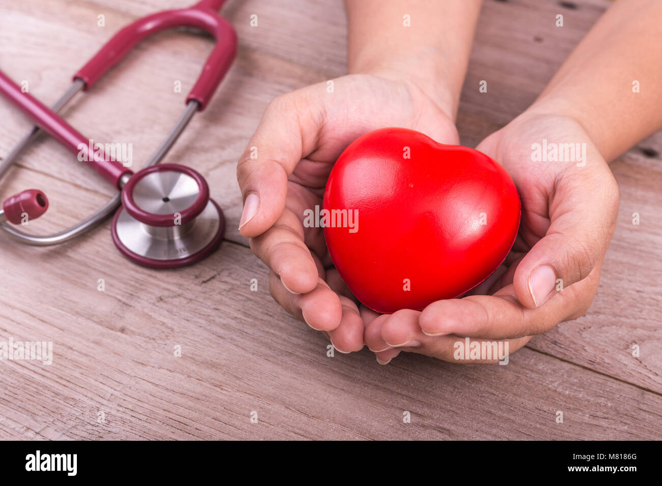 Check heart Concept : Woman hands holding red heart and stethoscope on ...
