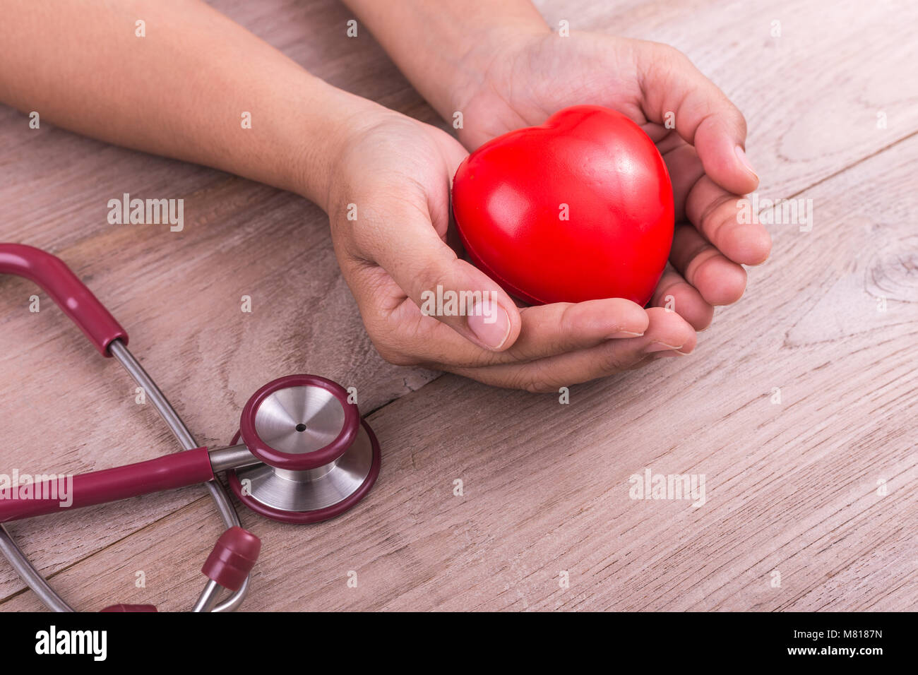 Check heart Concept : Woman hands holding red heart and stethoscope on ...
