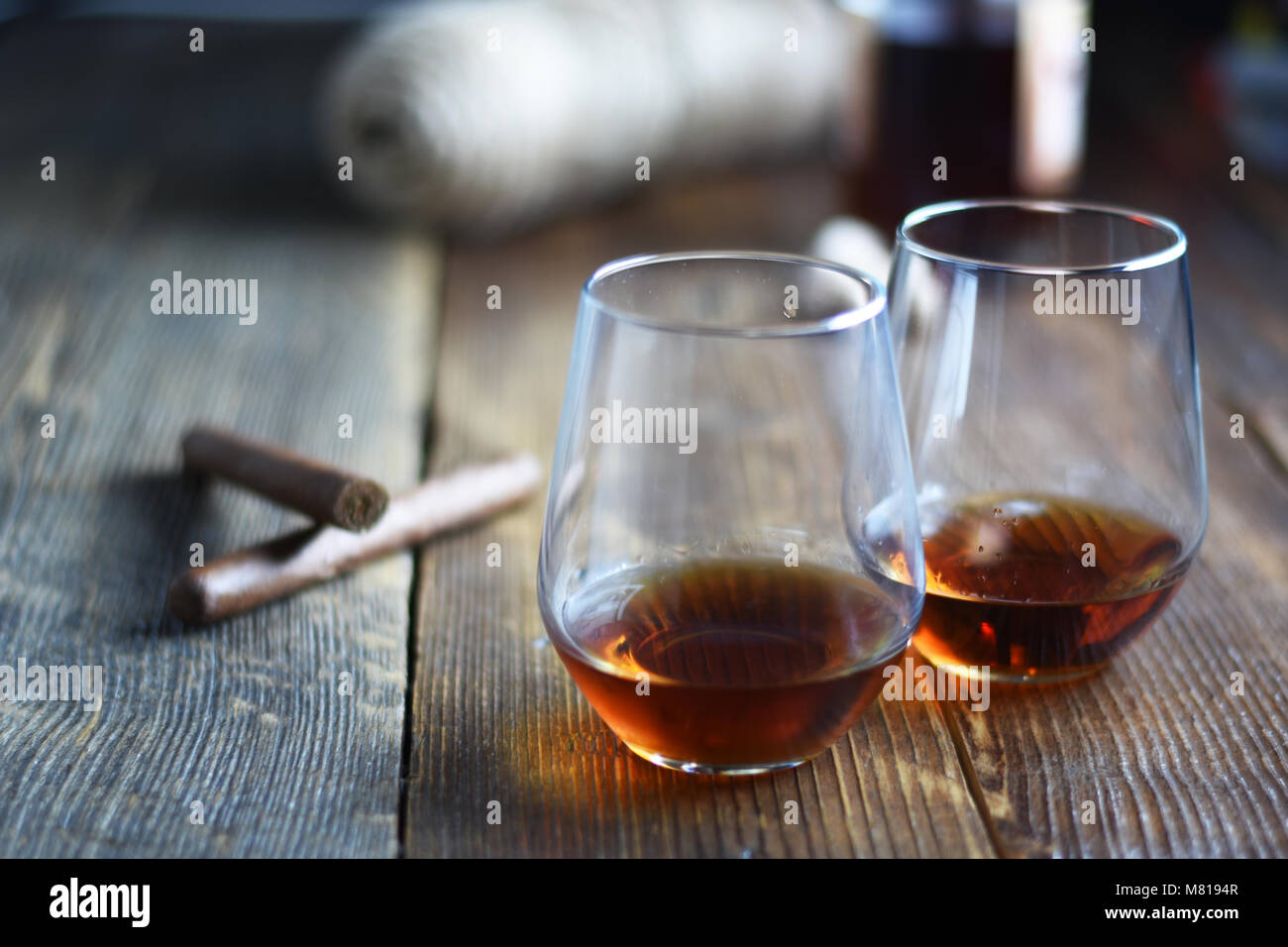 Vintage tools of Glass of rum on a rustic wooden table with cigars and ...