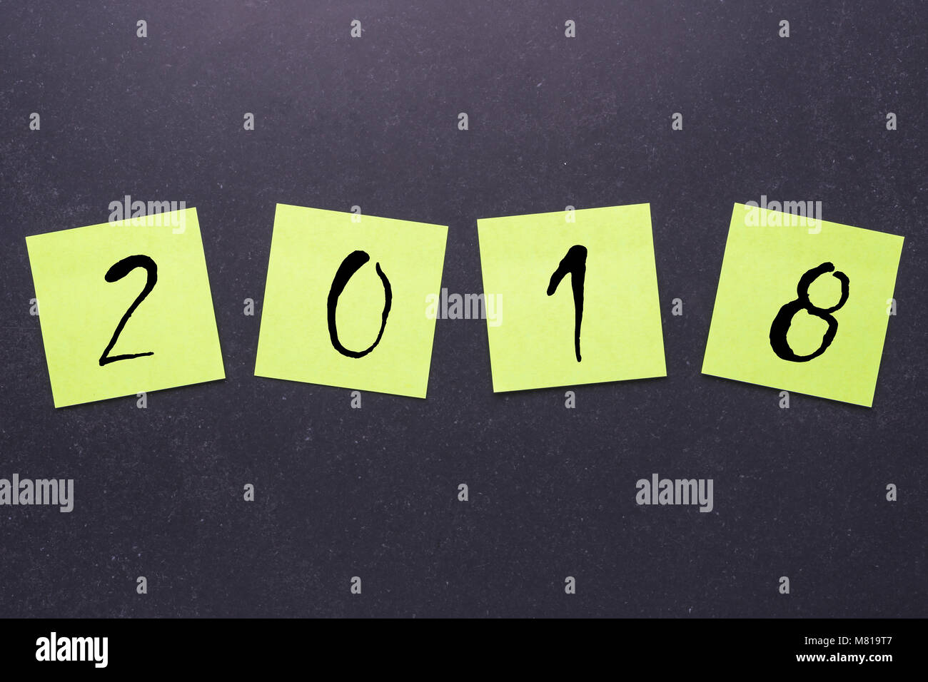 2018 write in green square paper note on black stone table background ...