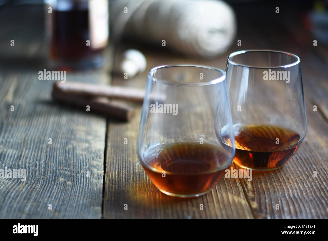 Vintage tools of Glass of rum on a rustic wooden table with cigars and ...