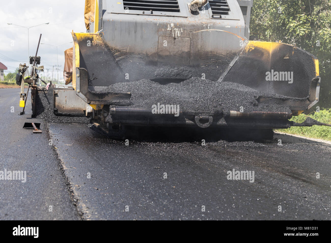 Outdoor working : Worker operating the process of building new asphalt ...