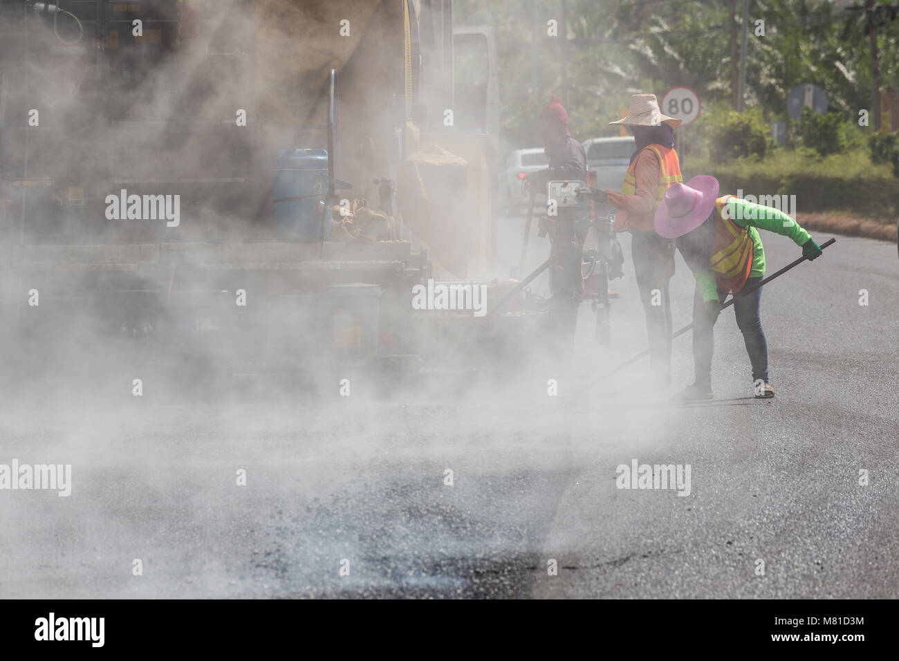 Outdoor working : Worker operating the process of building new asphalt ...