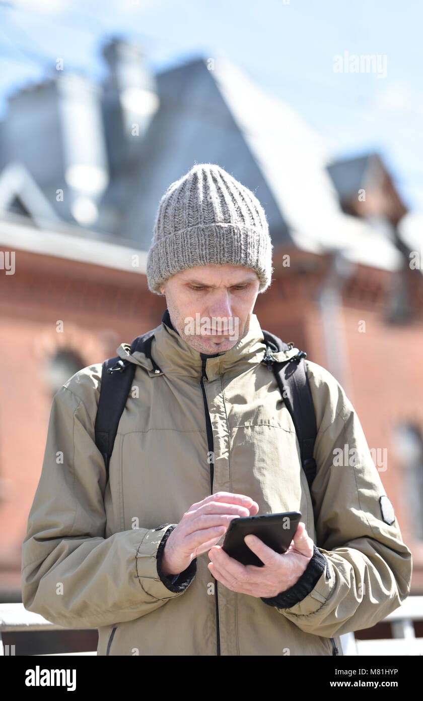 Man using tablet outdoors in a sunny spring day Stock Photo - Alamy