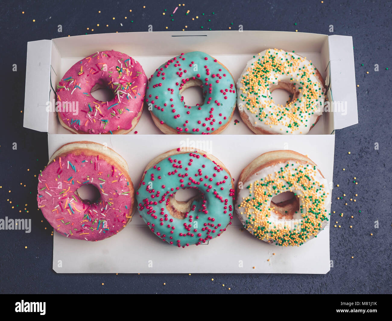 Donuts with colorful icing in box. Top view Stock Photo - Alamy