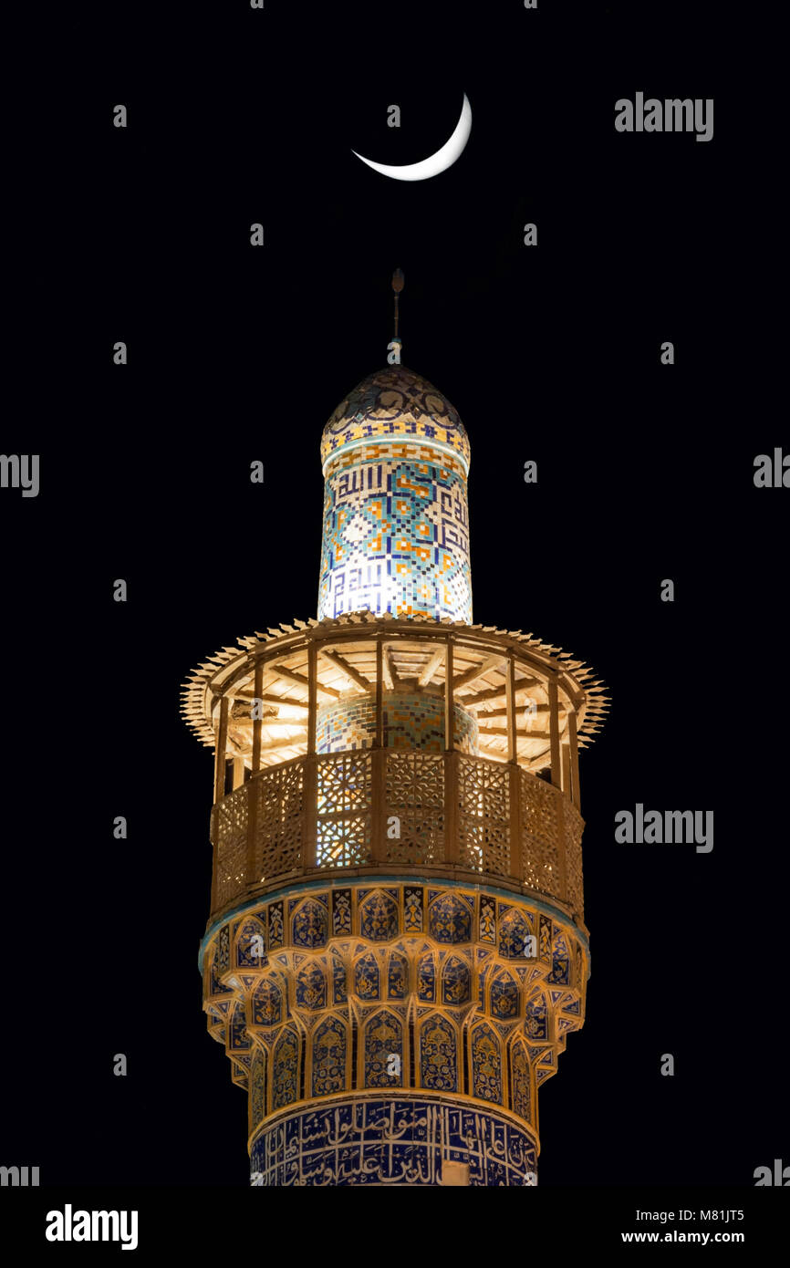 Night view on the top of minaret with lights and the moon on the ...
