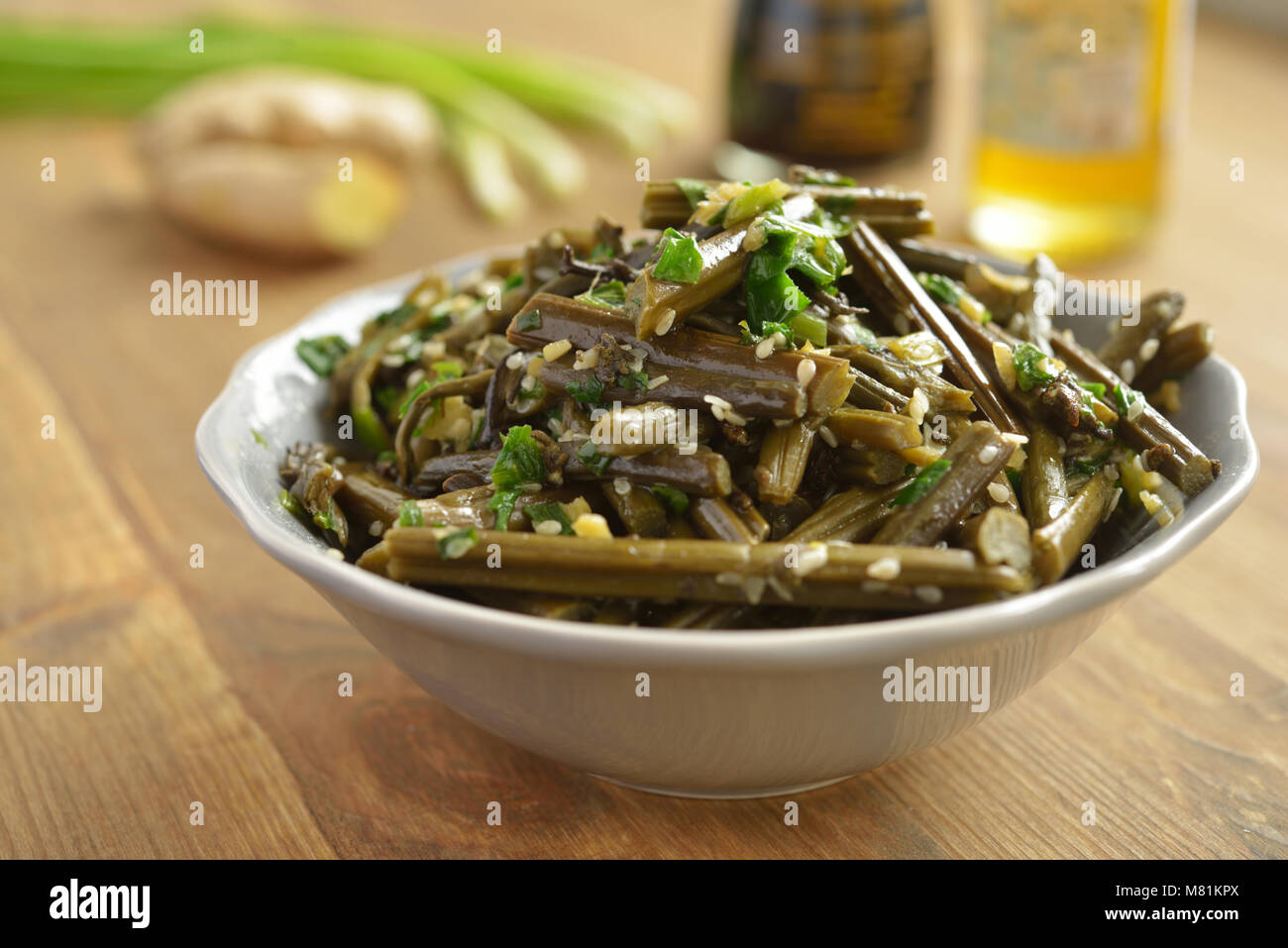 Sauteed bracken fern with sesame oil and seeds Stock Photo - Alamy