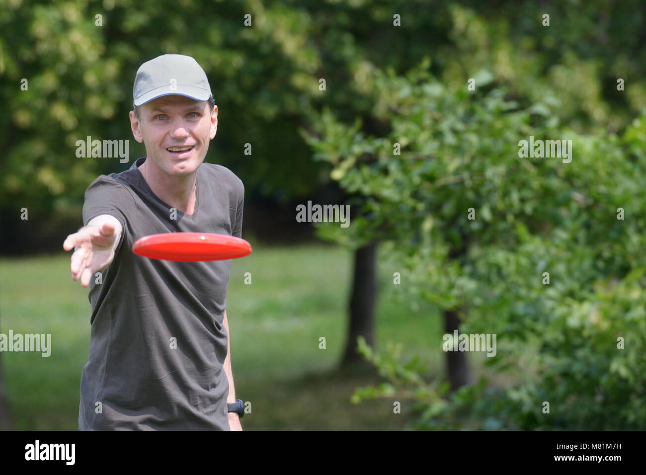 Man playing with frisbee in a park Stock Photo - Alamy