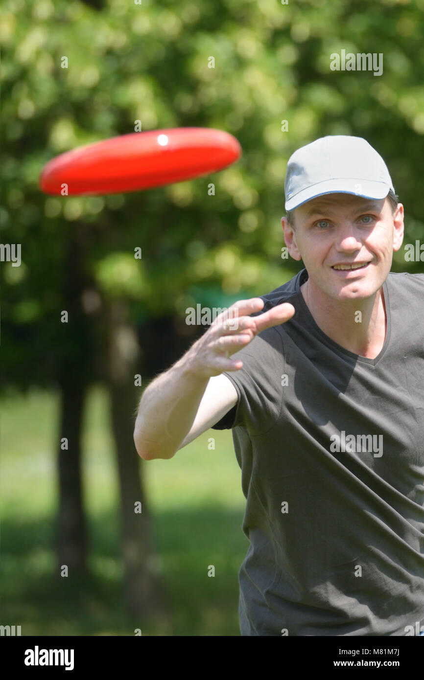 Man playing with frisbee in a park Stock Photo - Alamy