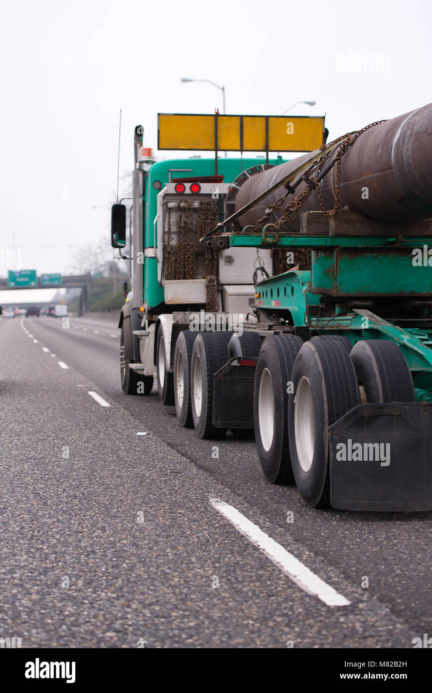 Green powerful American Big rig semi truck with long open flat bed semi ...