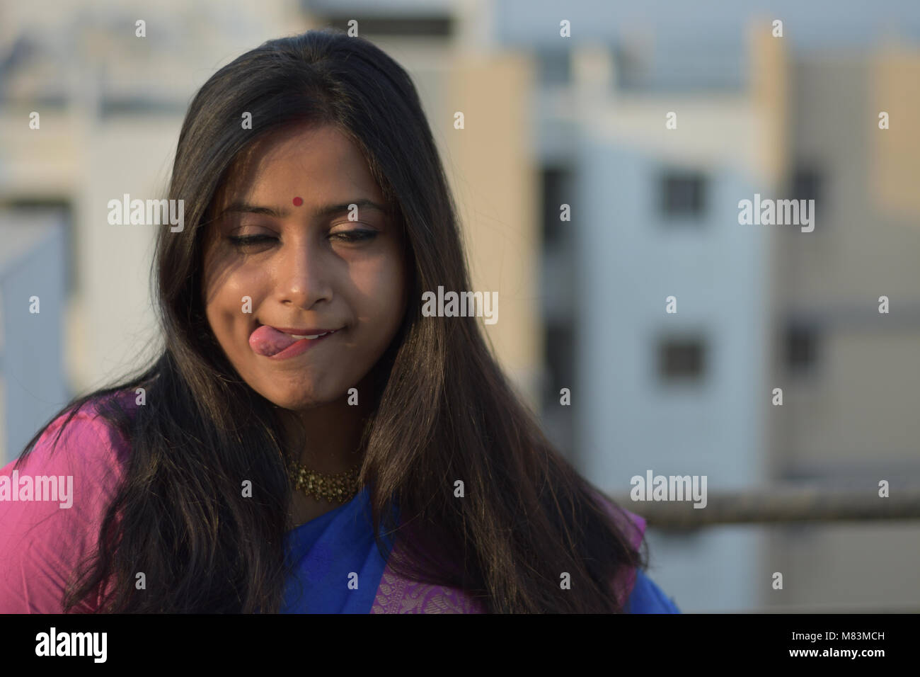 Beautiful young lady making face on rooftop outdoor Stock Photo - Alamy