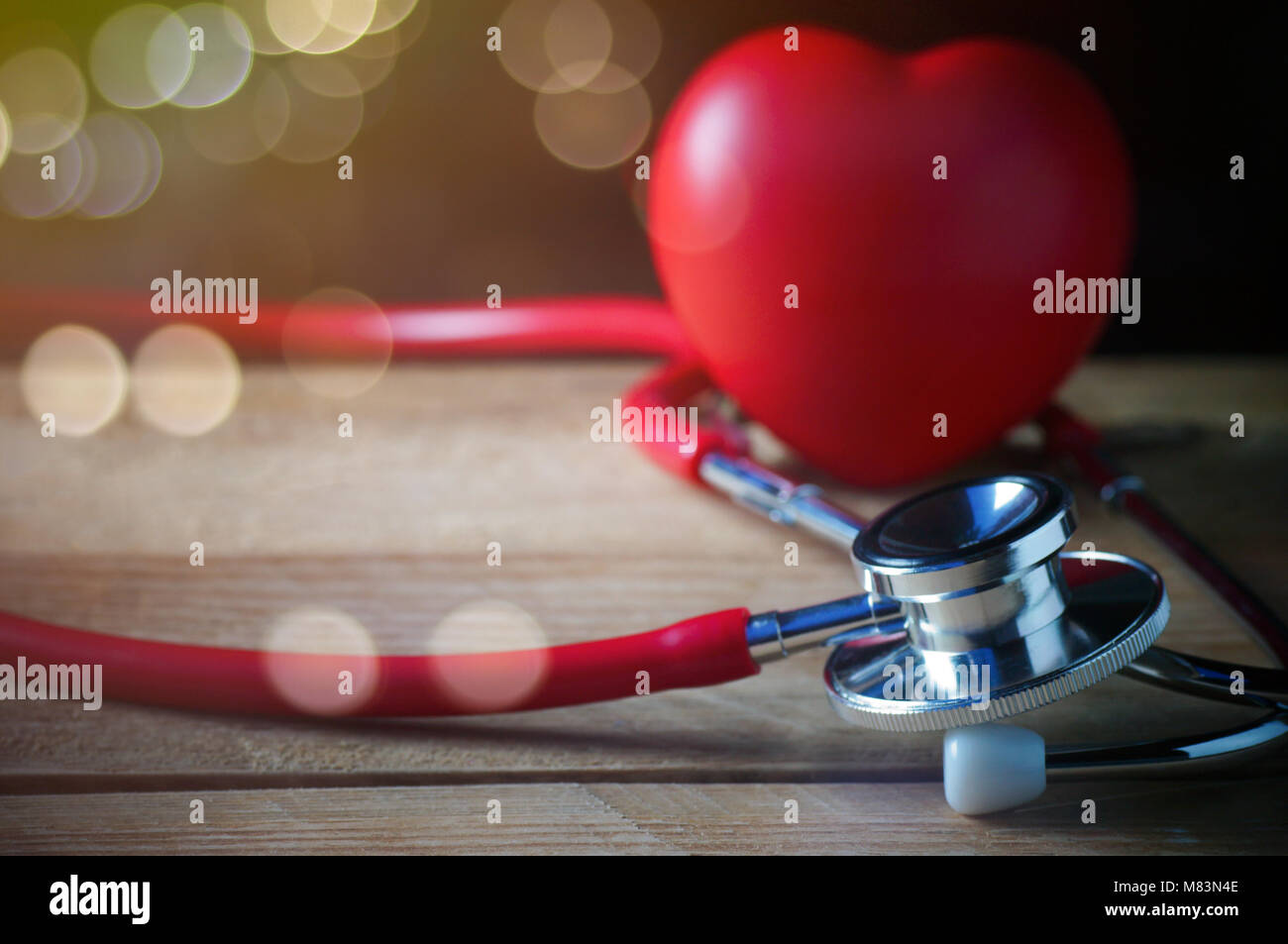 steth and red heart shape with glass of water on wood table, concept of ...