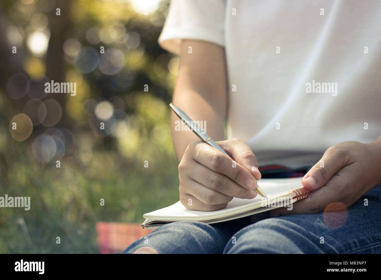 close up young women writing on notebook in park, concept in education ...