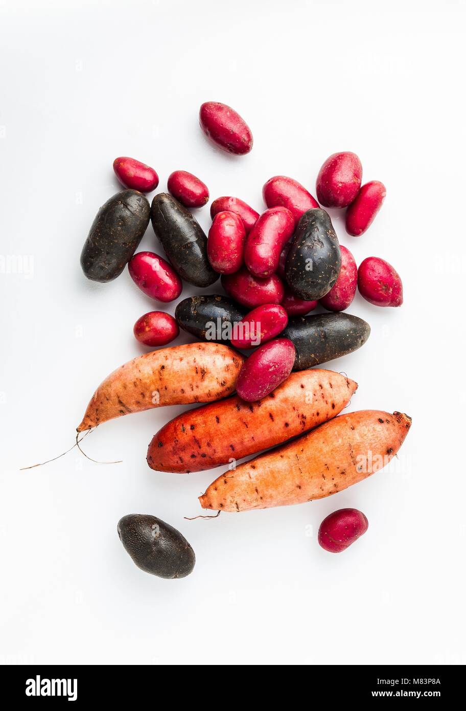 Different varieties in form and color of potatoes on a white isolated ...
