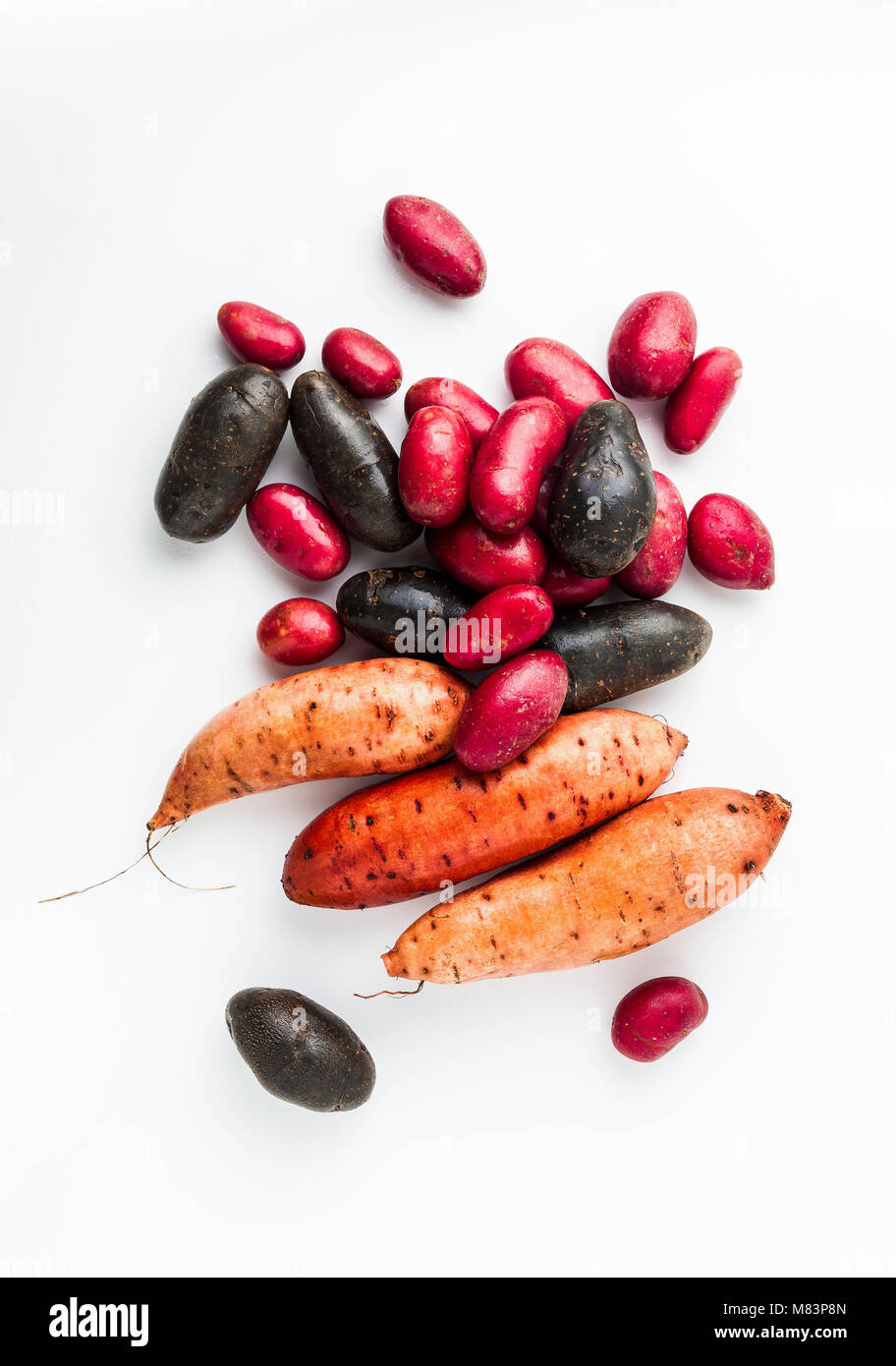 Different varieties in form and color of potatoes on a white isolated ...