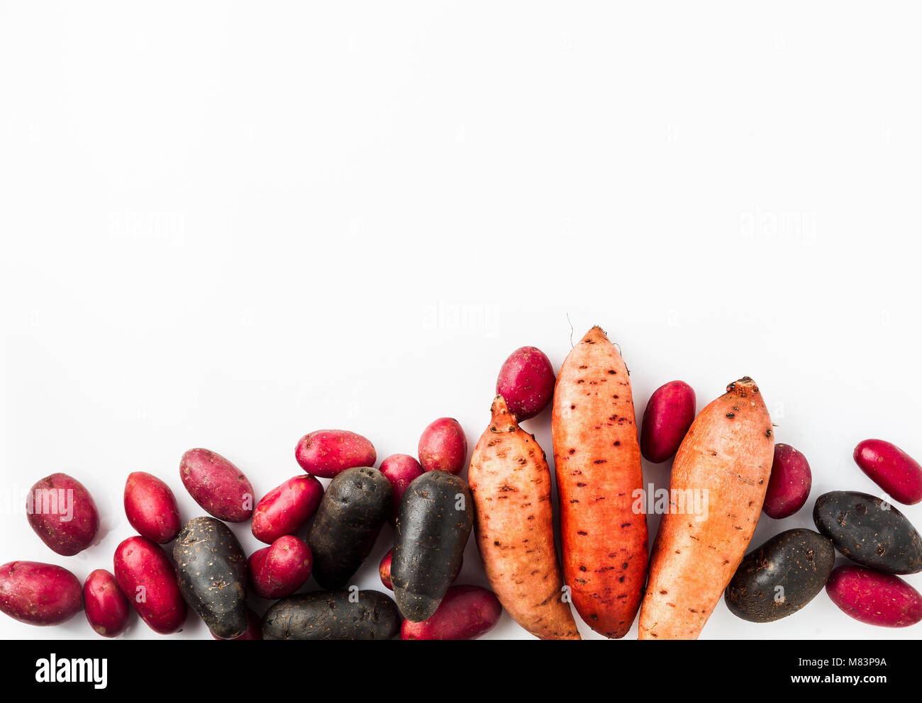 Different varieties in form and color of potatoes on a white isolated ...