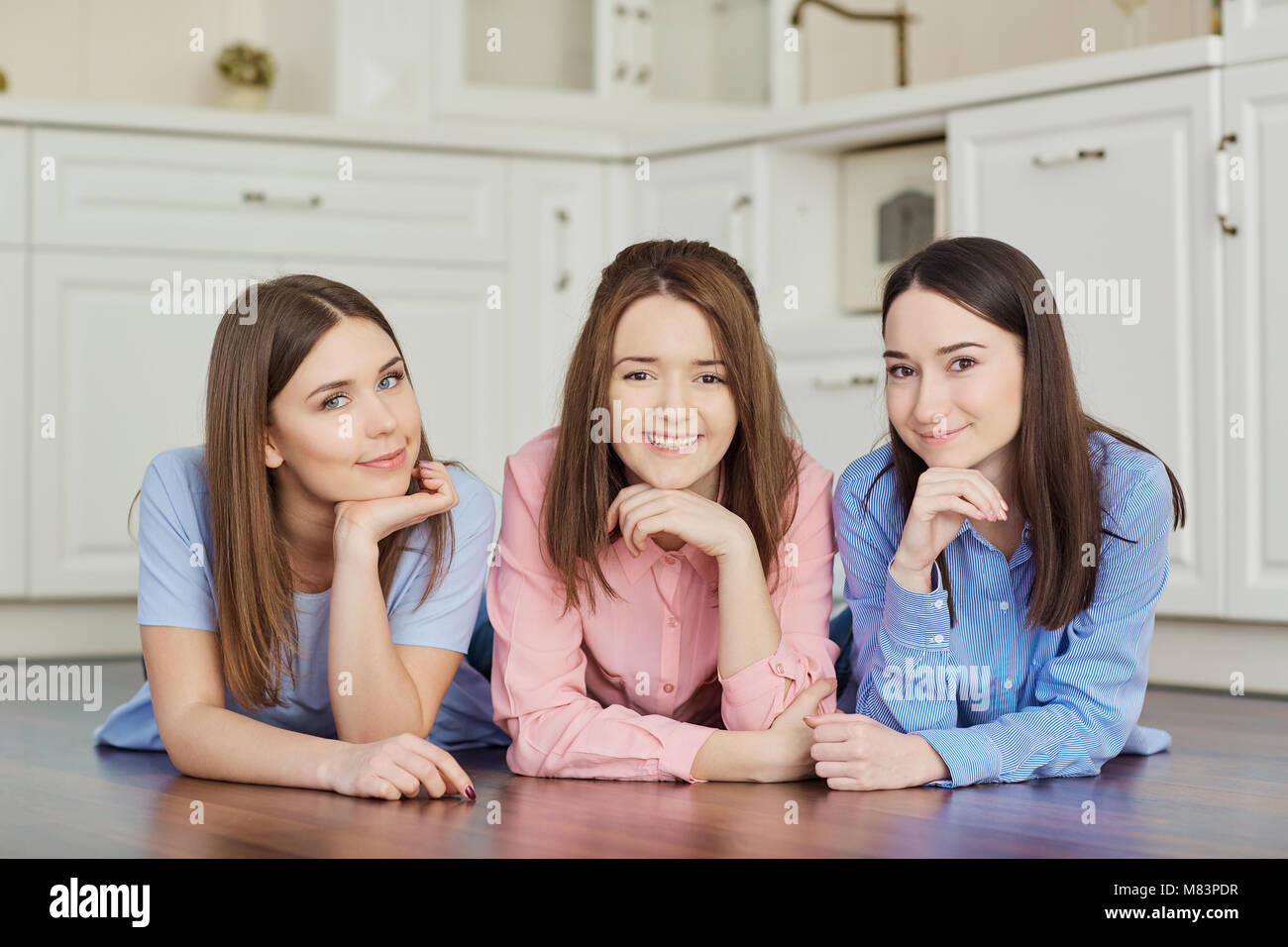 Portrait of a group of girls in casual clothes lying on the floor in ...