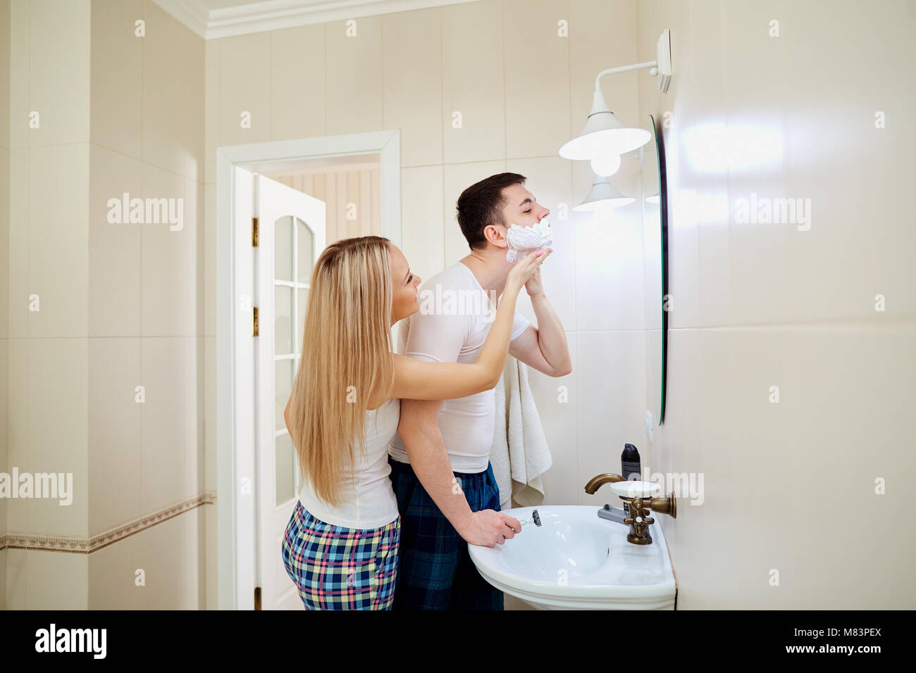 Couple in the morning in the bathroom doing personal hygiene. Romantic ...