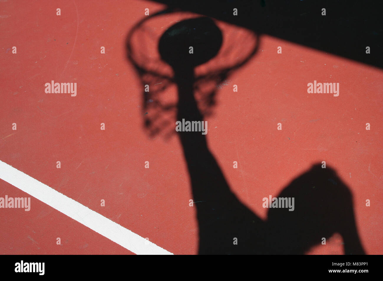 A Shadow Basketball player dunking on red court Stock Photo - Alamy