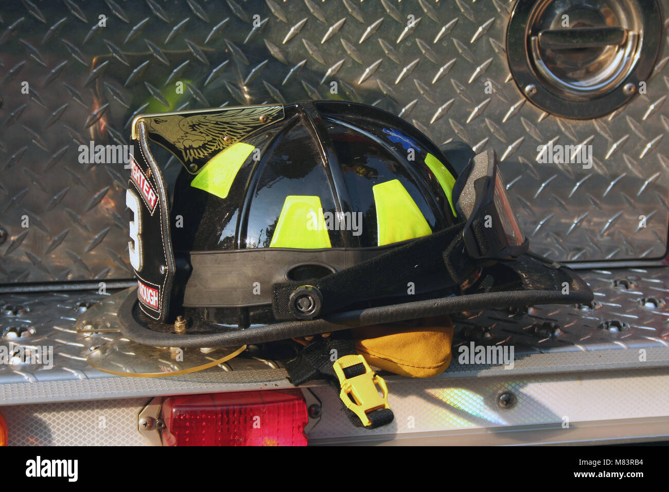 a Fireman helmet on the side of a firetruck Stock Photo - Alamy