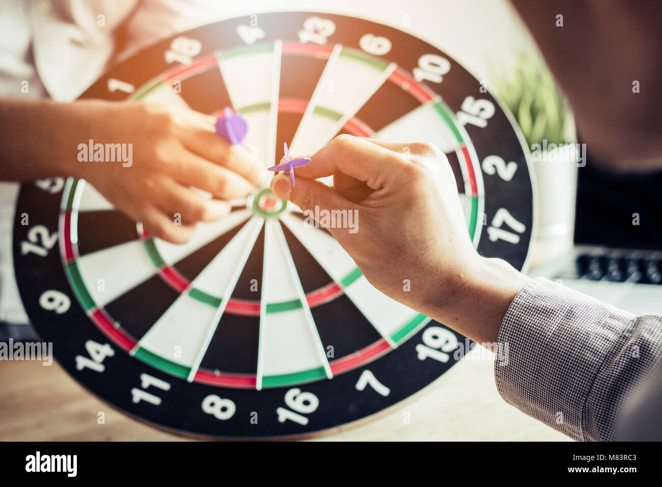 hand holding dart to goal on board with background Stock Photo - Alamy
