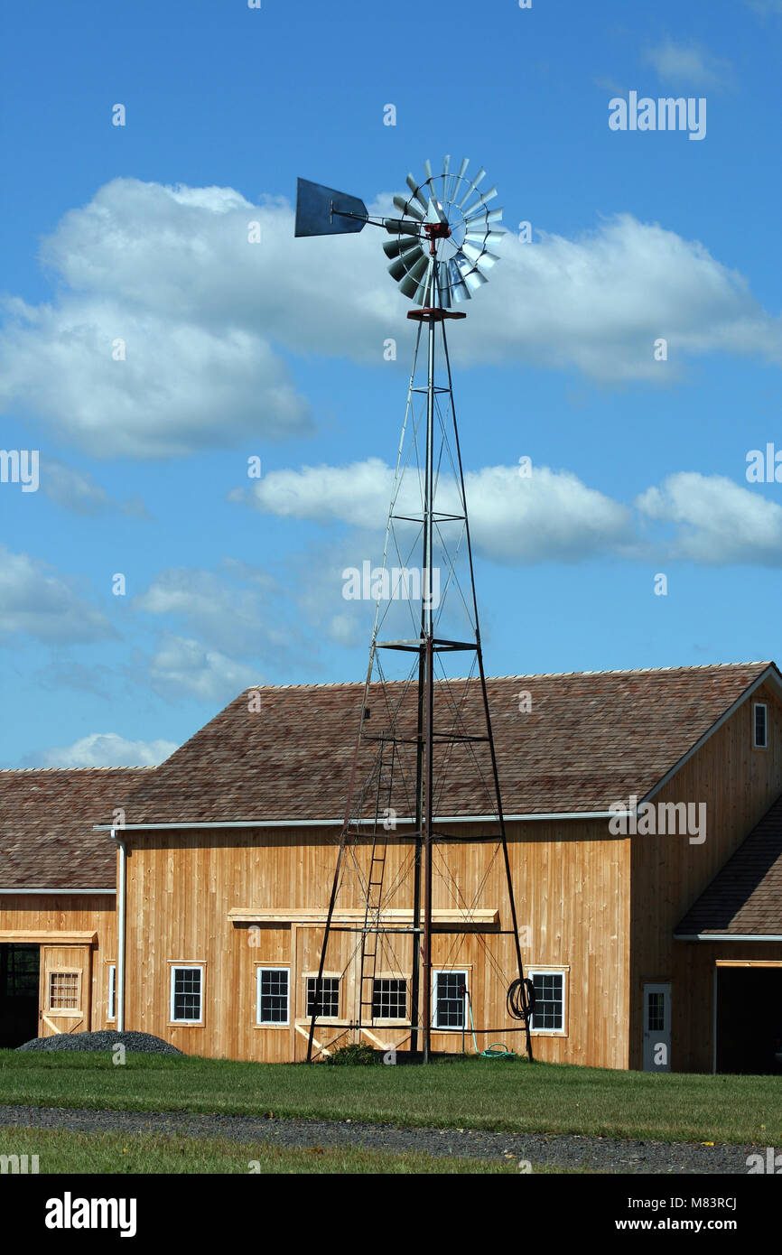 A Windmill with new barn against a cloudy blue sky Stock Photo - Alamy