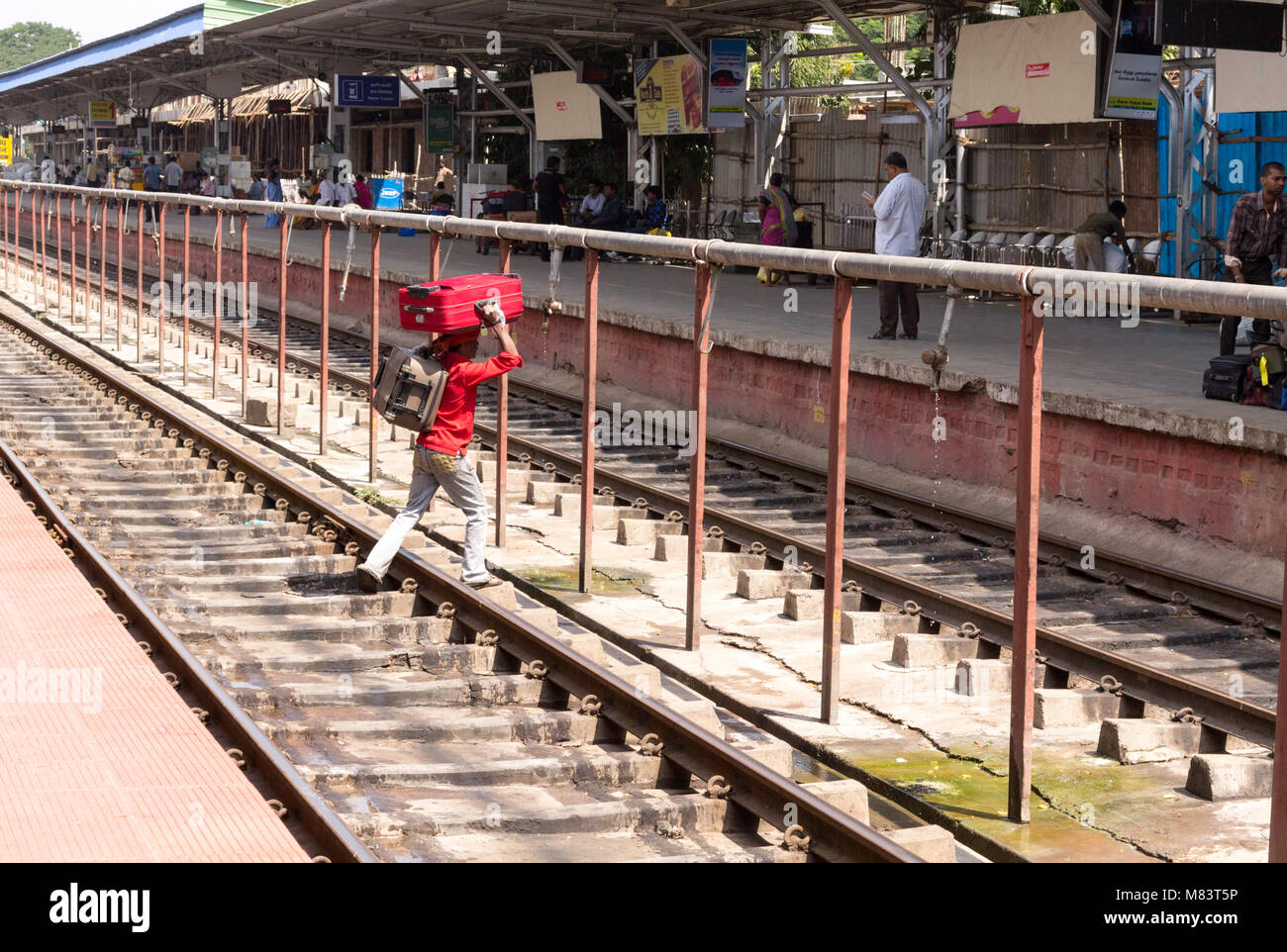 Railway porter at Kerala railway station walking across the railway ...