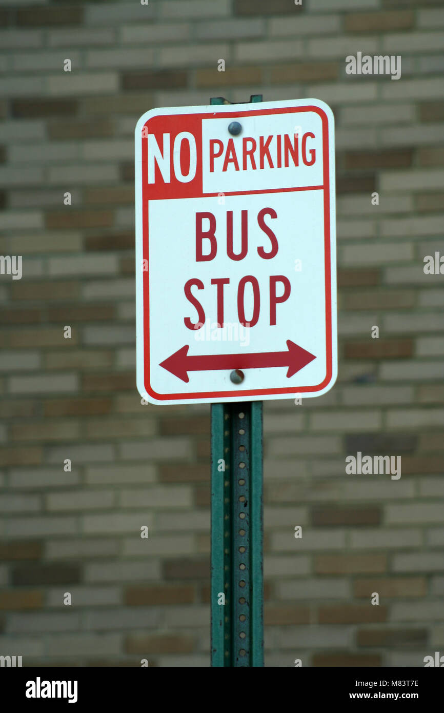 Bus stop and no parking sign against a brick wall Stock Photo - Alamy