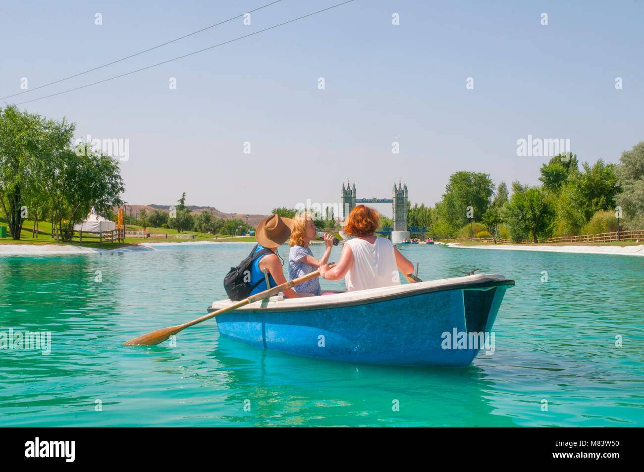 Three women rowing in a boat. Pond, Parque Europa, Torrejon de Ardoz ...
