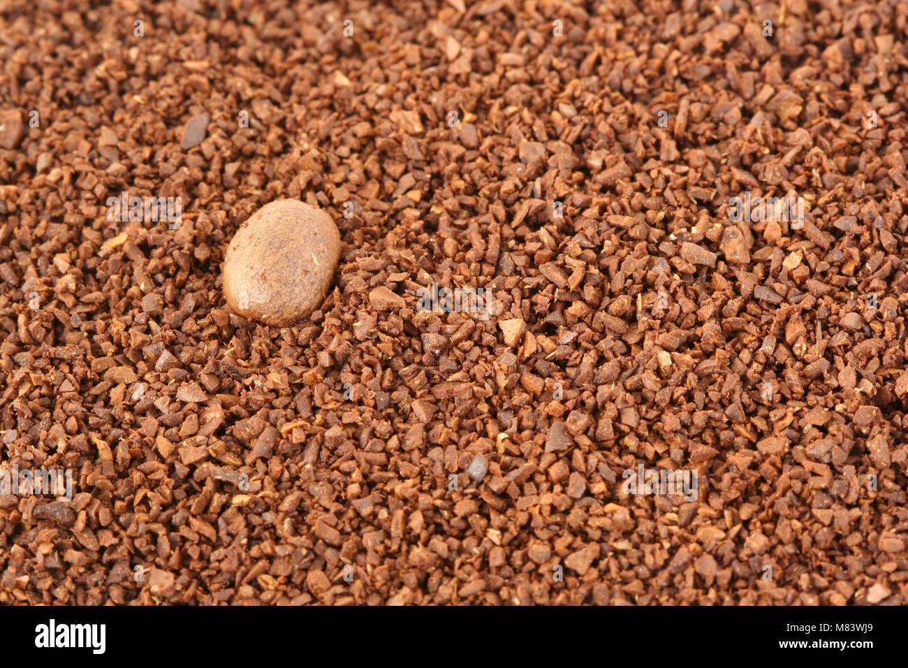 A coffee grinds with one bean background Stock Photo - Alamy