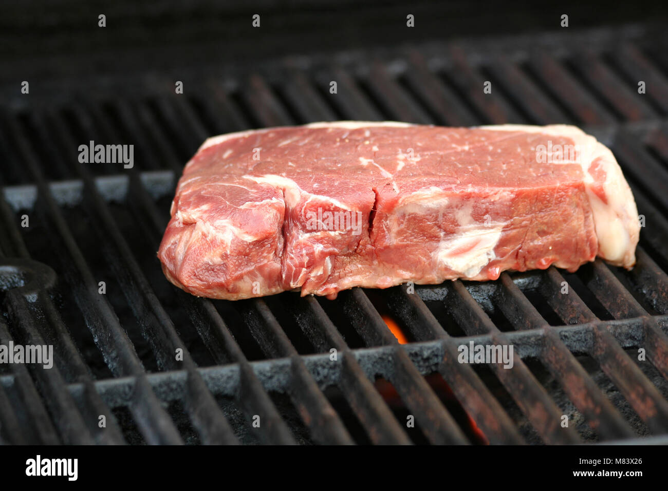 A Raw steak on a BBQ grill Stock Photo - Alamy
