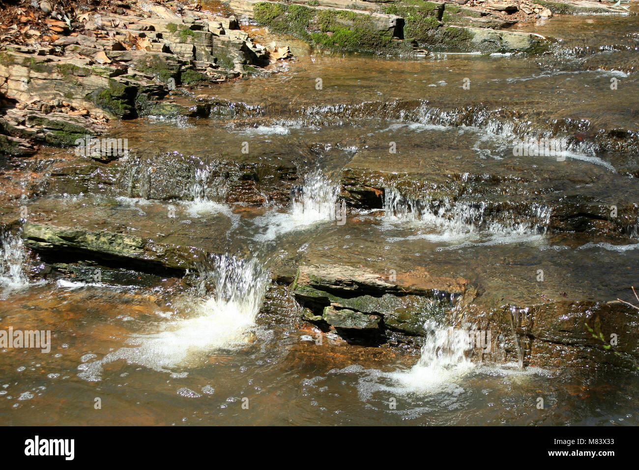 A small water fall in a stream Stock Photo - Alamy
