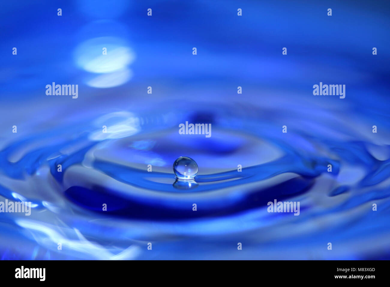 A Blue water droplet falling Stock Photo - Alamy