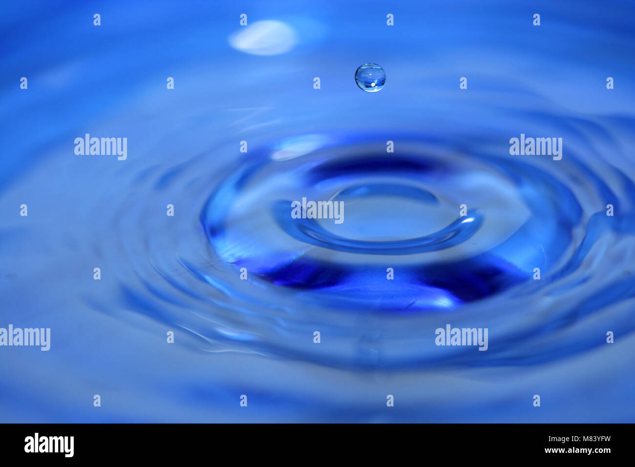 A Blue water droplet falling Stock Photo - Alamy