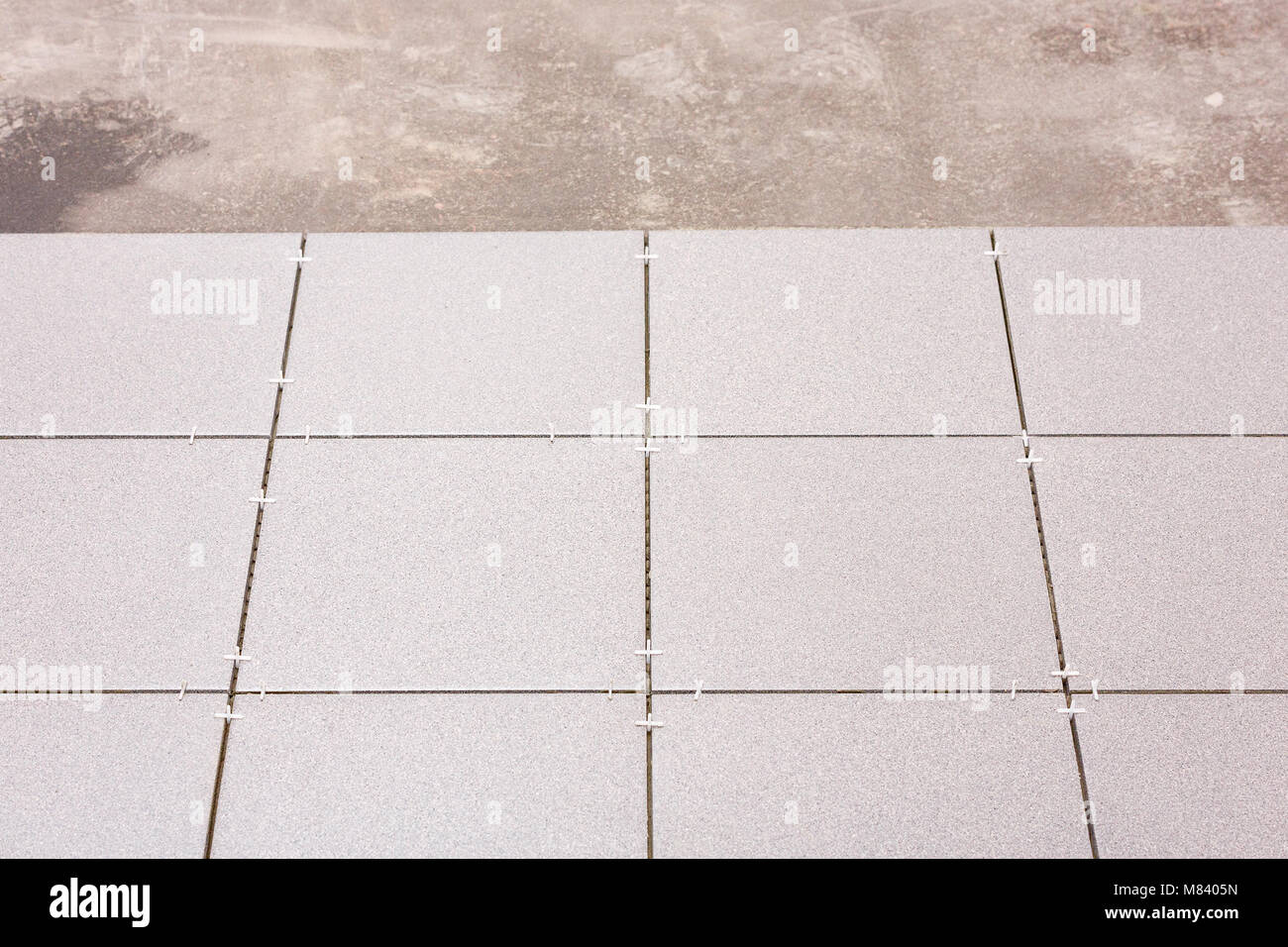 Fragment of the floor, in the process of laying ceramic tiles, close-up ...
