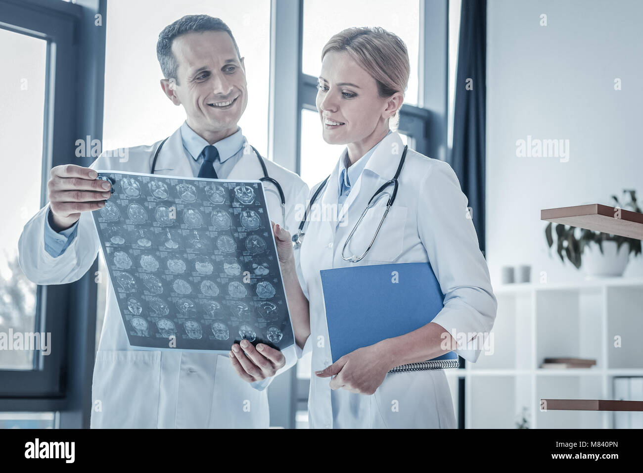 Interested skilled doctor standing and looking at his colleague Stock ...