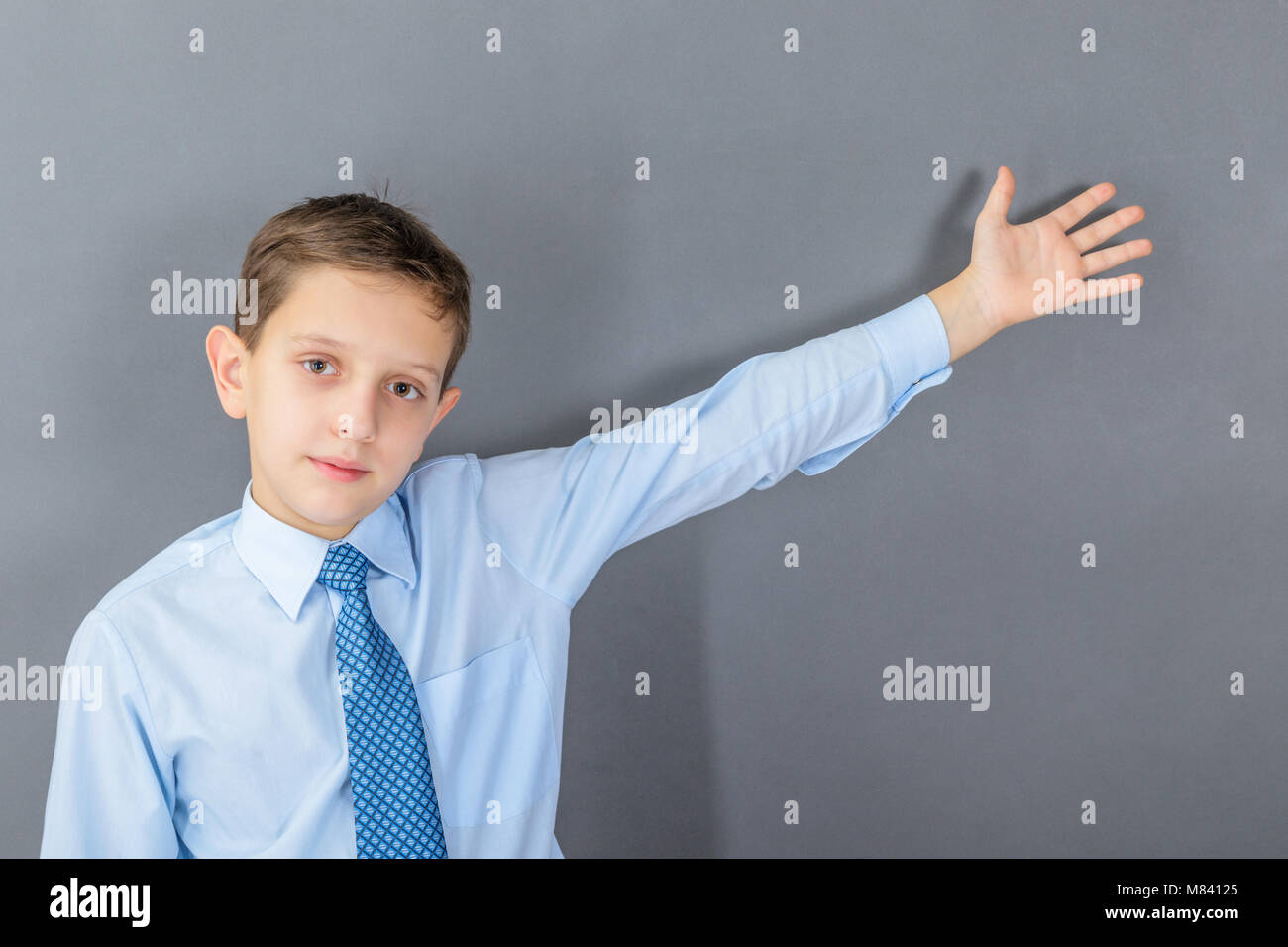 A boy pointing a gesture at something on the school board. Blackboard ...