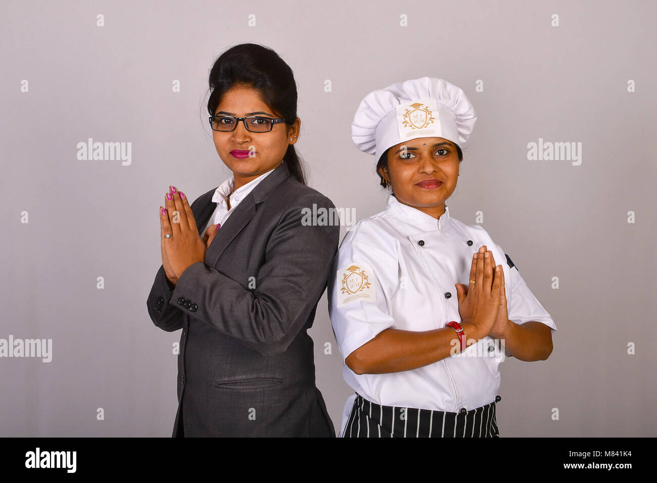 Female chef and staff in a restaurant standing with Namaste greeting ...