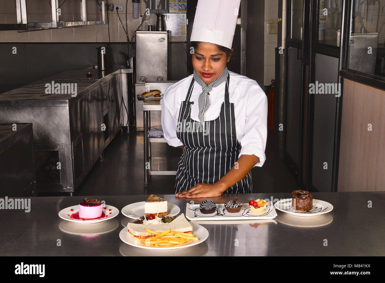 Female chef checking on food in the kitchen Stock Photo - Alamy
