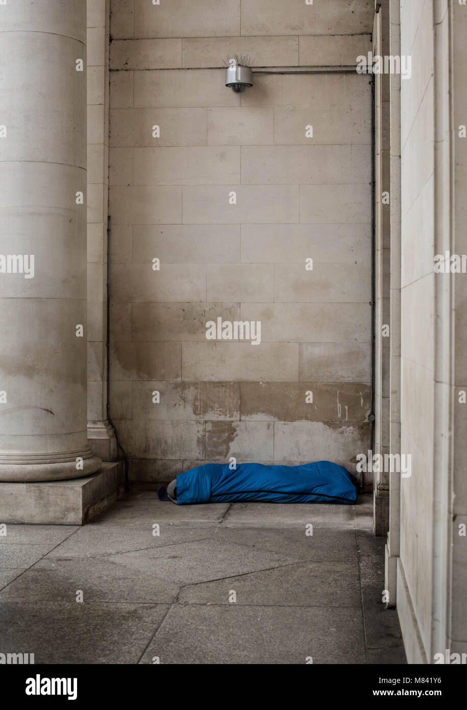 Homeless man sleeping under a security camera hi-res stock photography ...