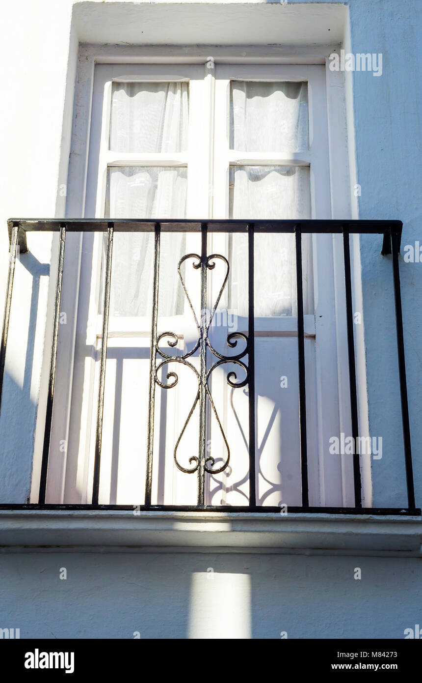 Stylish balcony with a metal railing, solid architectural element, a ...
