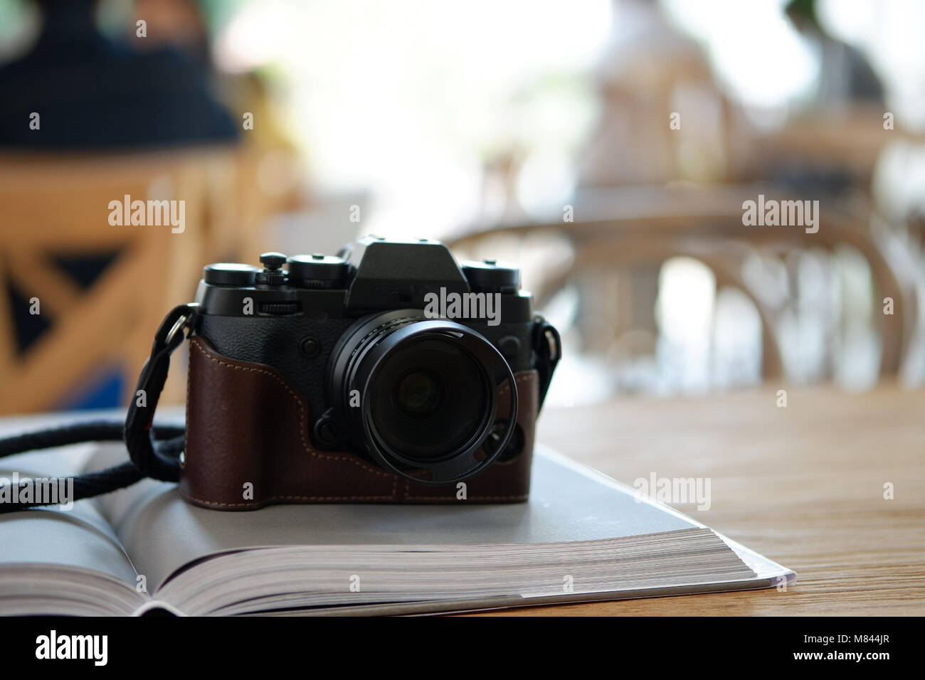 old camera on book on table cafe background Stock Photo - Alamy