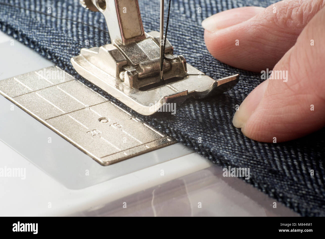 sewing machine sews denim fabric Stock Photo - Alamy