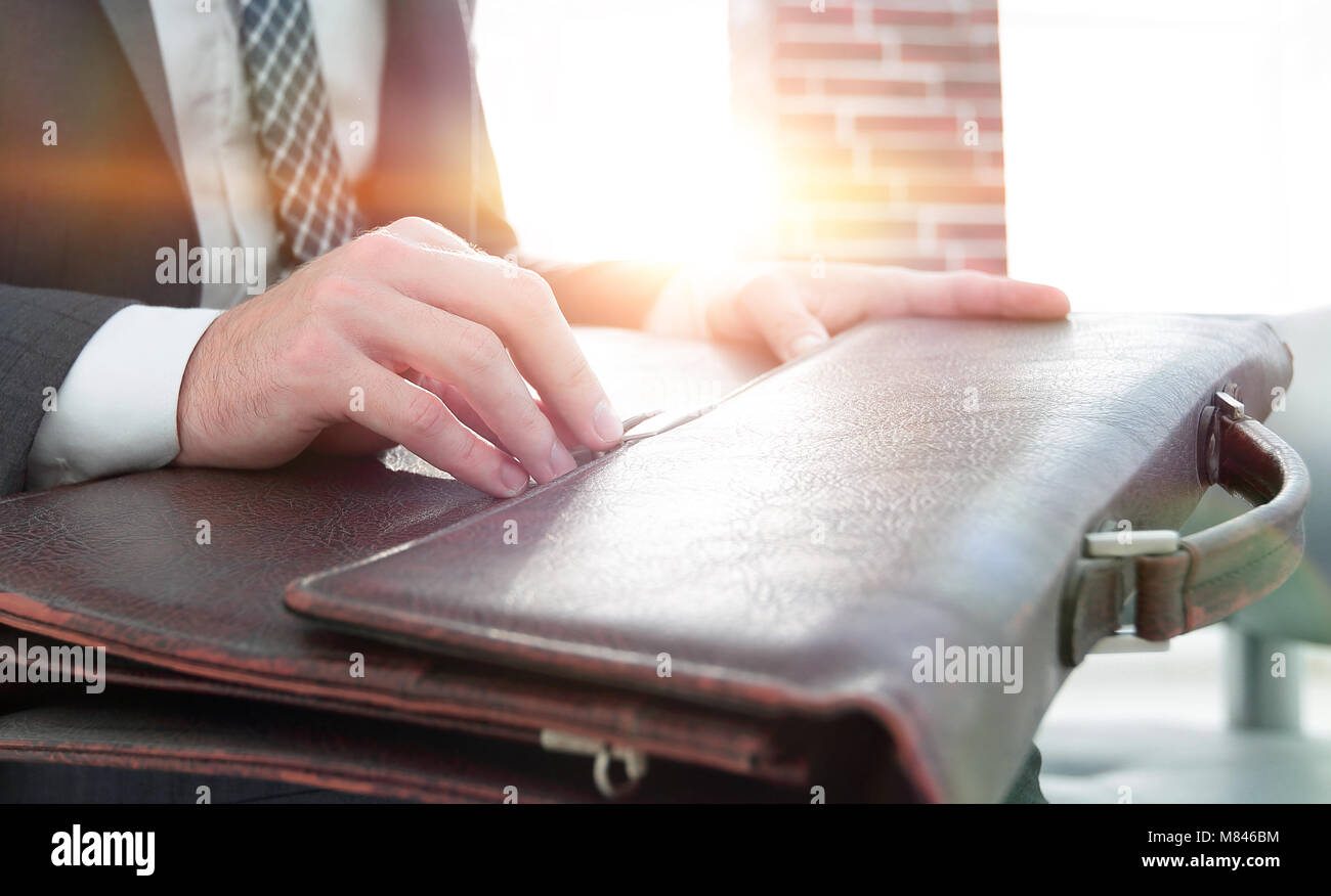 businessman's hand with suitecase in a modern office Stock Photo - Alamy