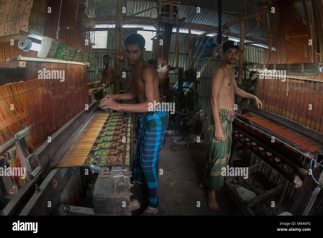 SIRAJANJ, BANGLADESH - APRIL 17, 2016: A worker weaves cloth at a ...