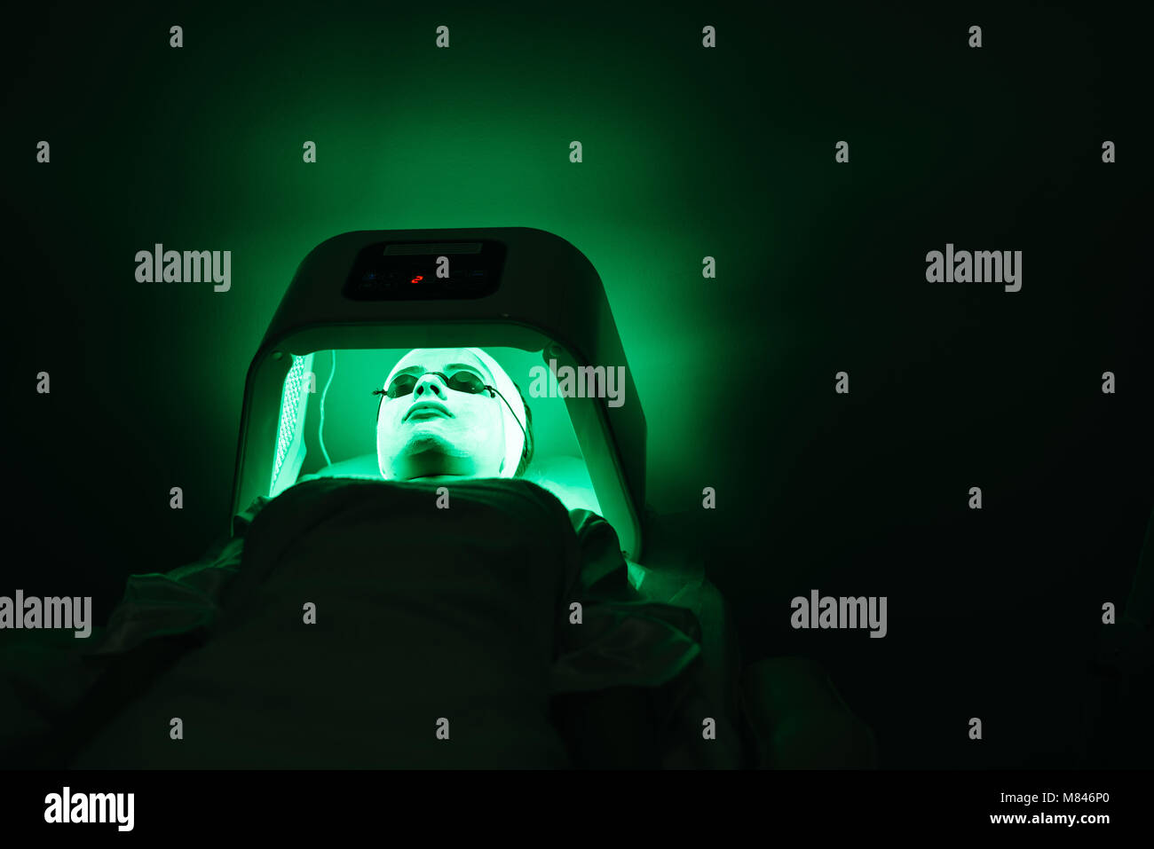 The young woman with mask and solarium glasses is relaxing in the ...