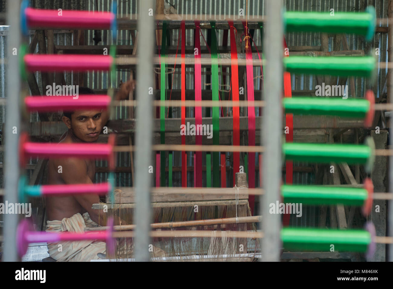 SIRAJANJ, BANGLADESH - APRIL 17, 2016: A worker weaves cloth at a ...
