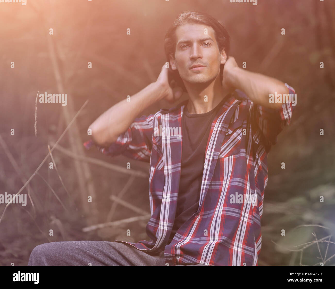 confident young man sitting in the woods Stock Photo - Alamy