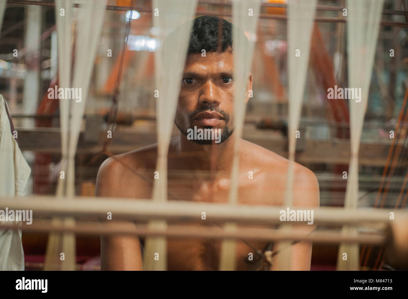 SIRAJANJ, BANGLADESH - APRIL 17, 2016: A worker weaves cloth at a ...