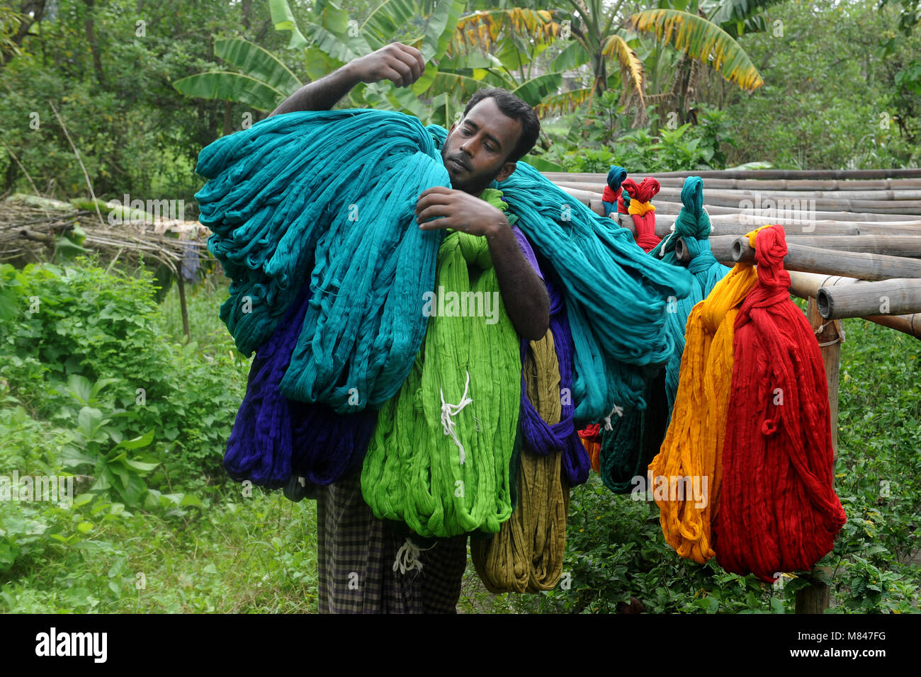 DHAKA, BANGLADESH - AUGUST 29, 2016: A worker weaves cloth at a ...